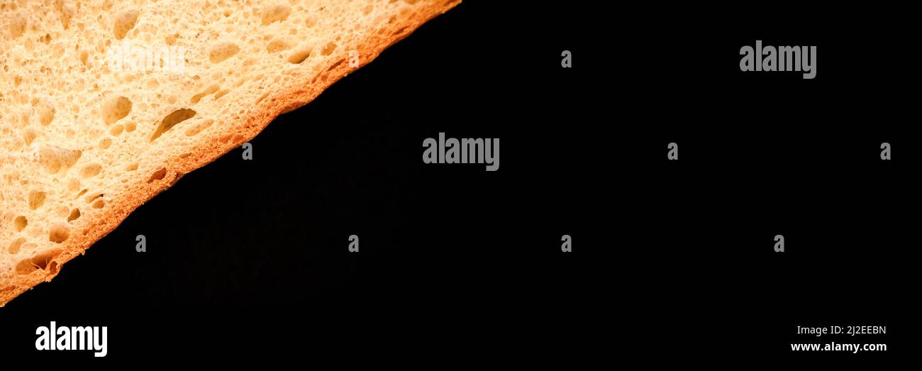slice of white bread close up isolated on a black background. rough ...