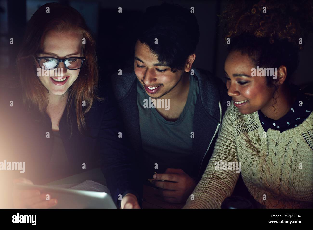 Putting in that extra hours as a team. Cropped shot of a group of young ...
