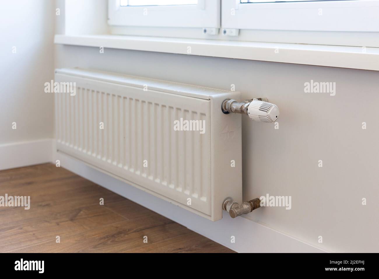 Wall mounted heating radiator with thermostat. Battery Stock Photo - Alamy