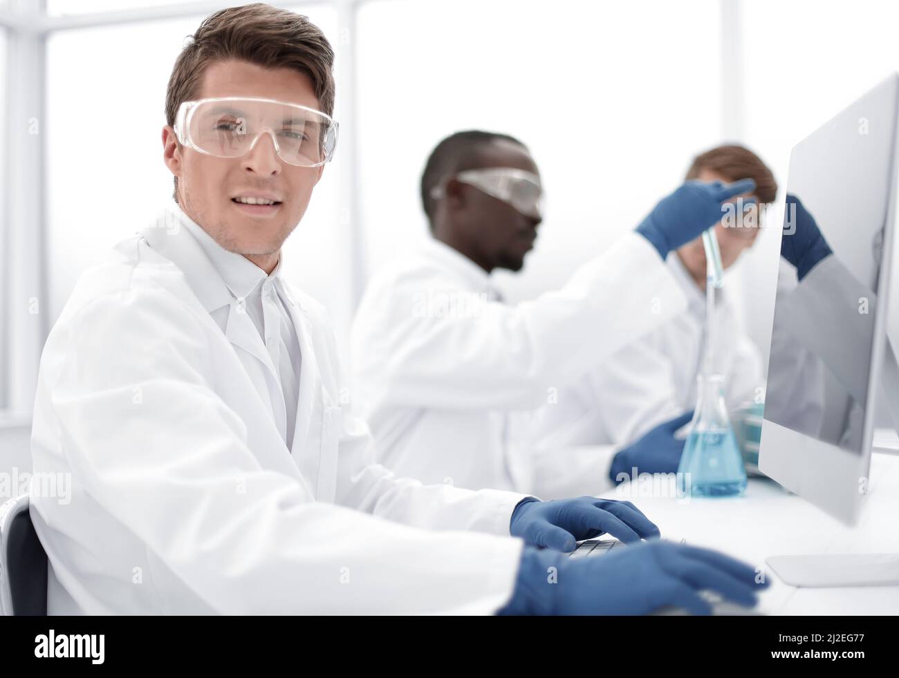 modern scientist sitting in front of a computer monito Stock Photo - Alamy