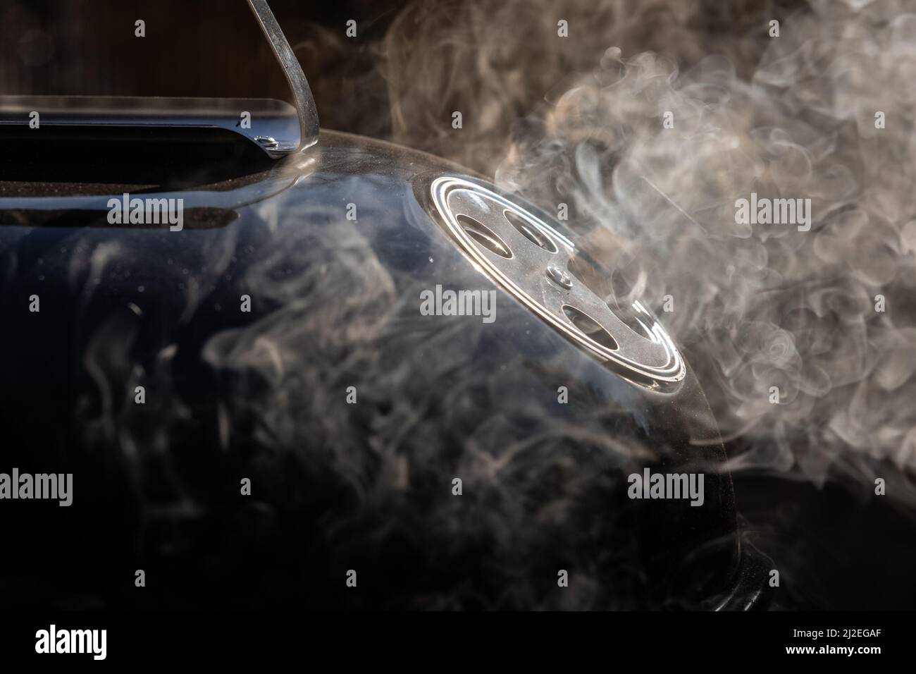 Smoke coming out from ventilation opening of a smoker grill. Round ...