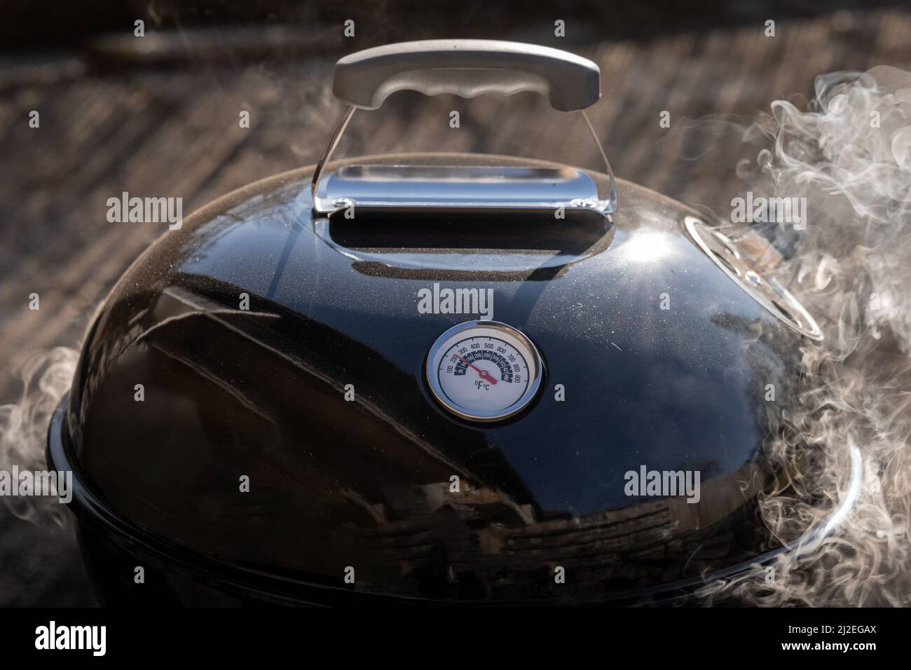 Smoke coming out from ventilation opening of a smoker grill. Round ...