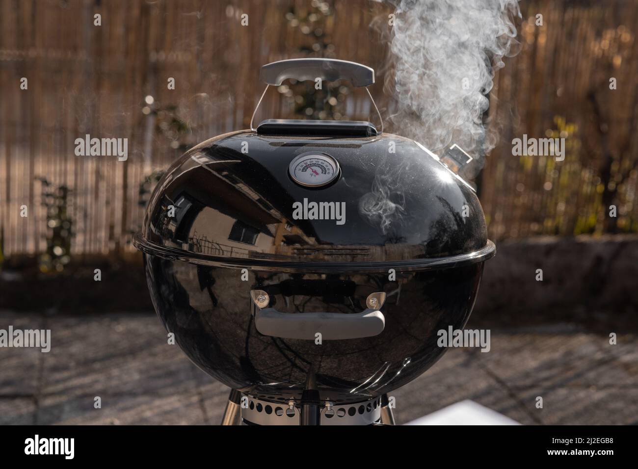 Smoke coming out from ventilation opening of a smoker grill. Round ...