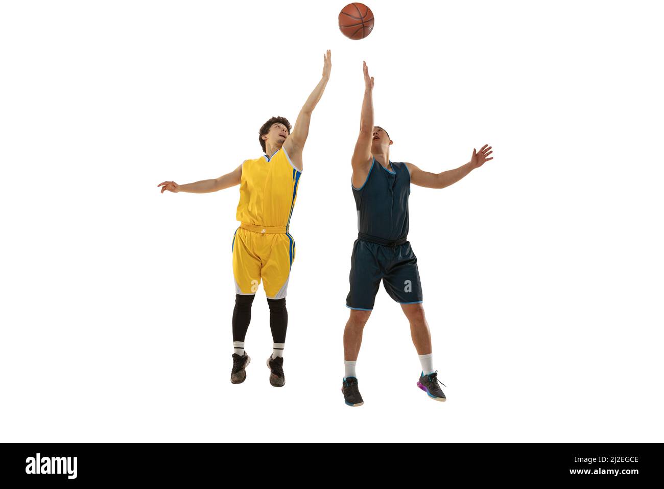 Dynamic portrait of two young basketball players jumping with ball ...