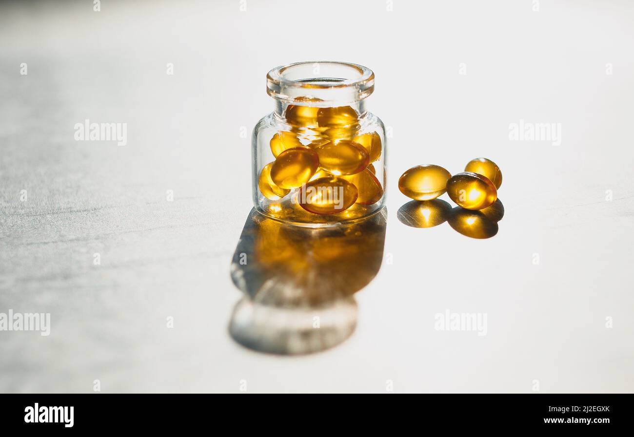 Cod liver oil capsules in glass bottle isolated on white background ...