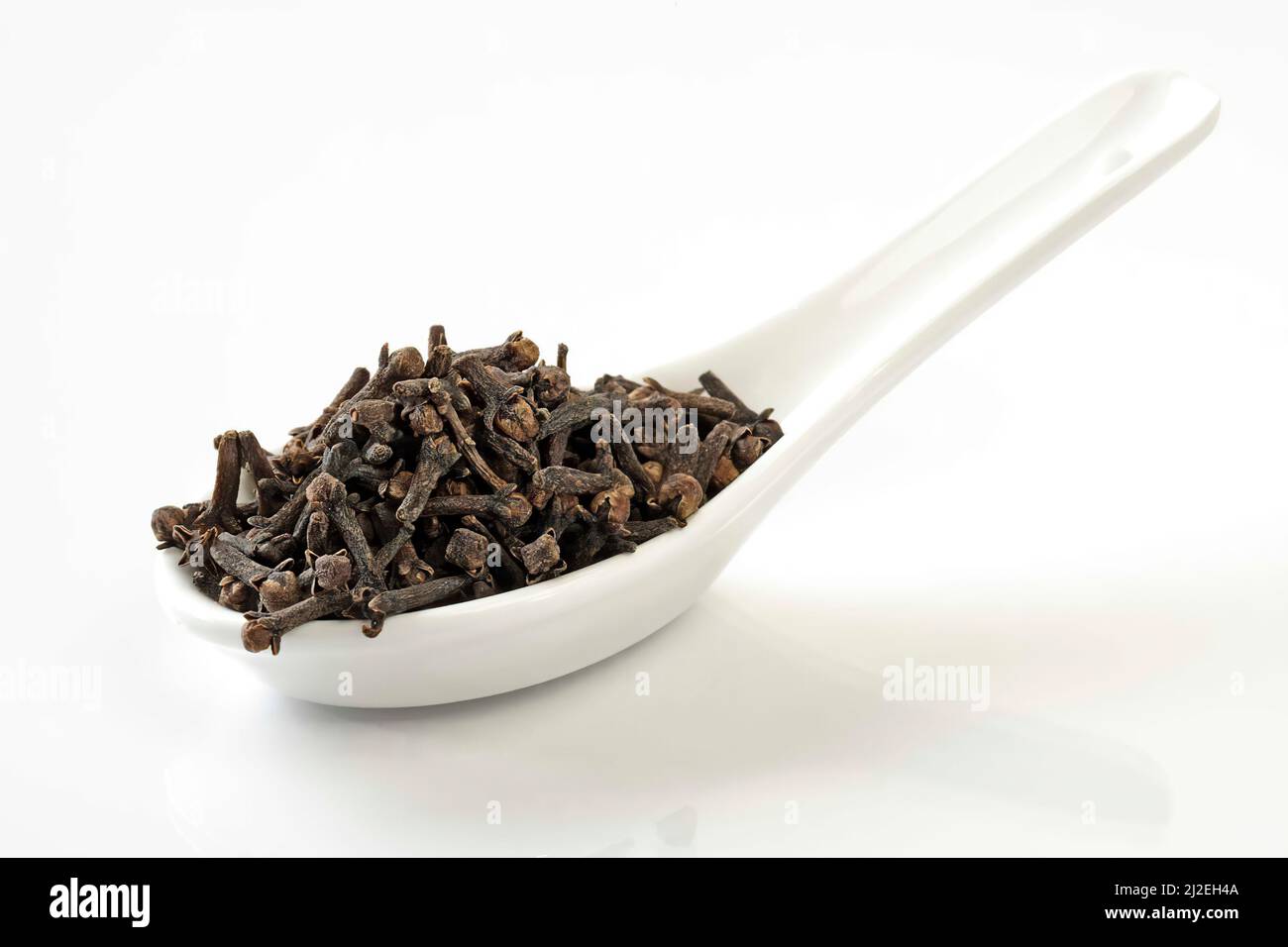 dried cloves in a spoon isolated on white Stock Photo - Alamy