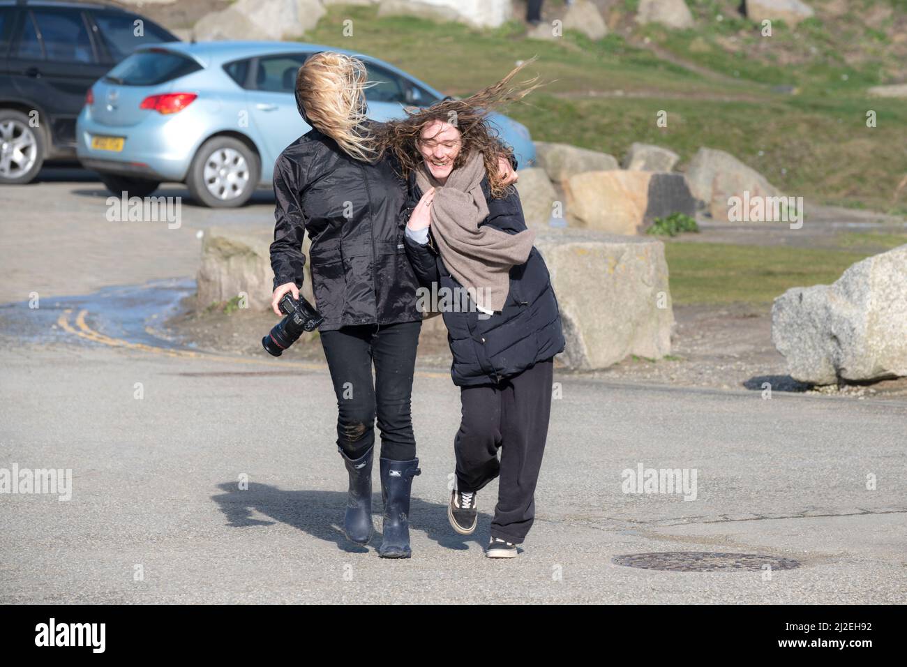 People walking in high winds brought by Storm Eunice in Newquay in ...