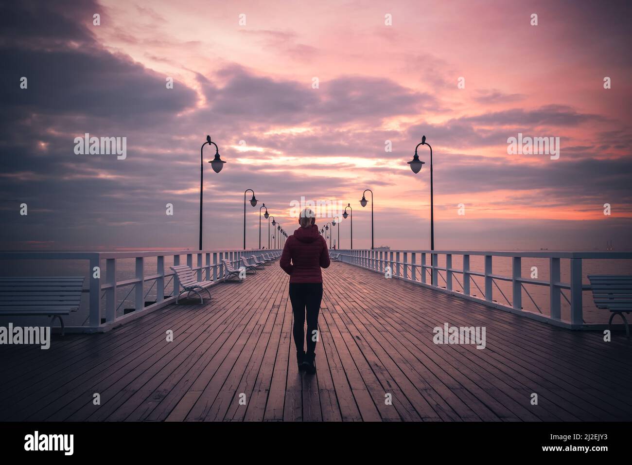 Atmospheric seaside concept with a woman. Girl on a wooden pier in ...