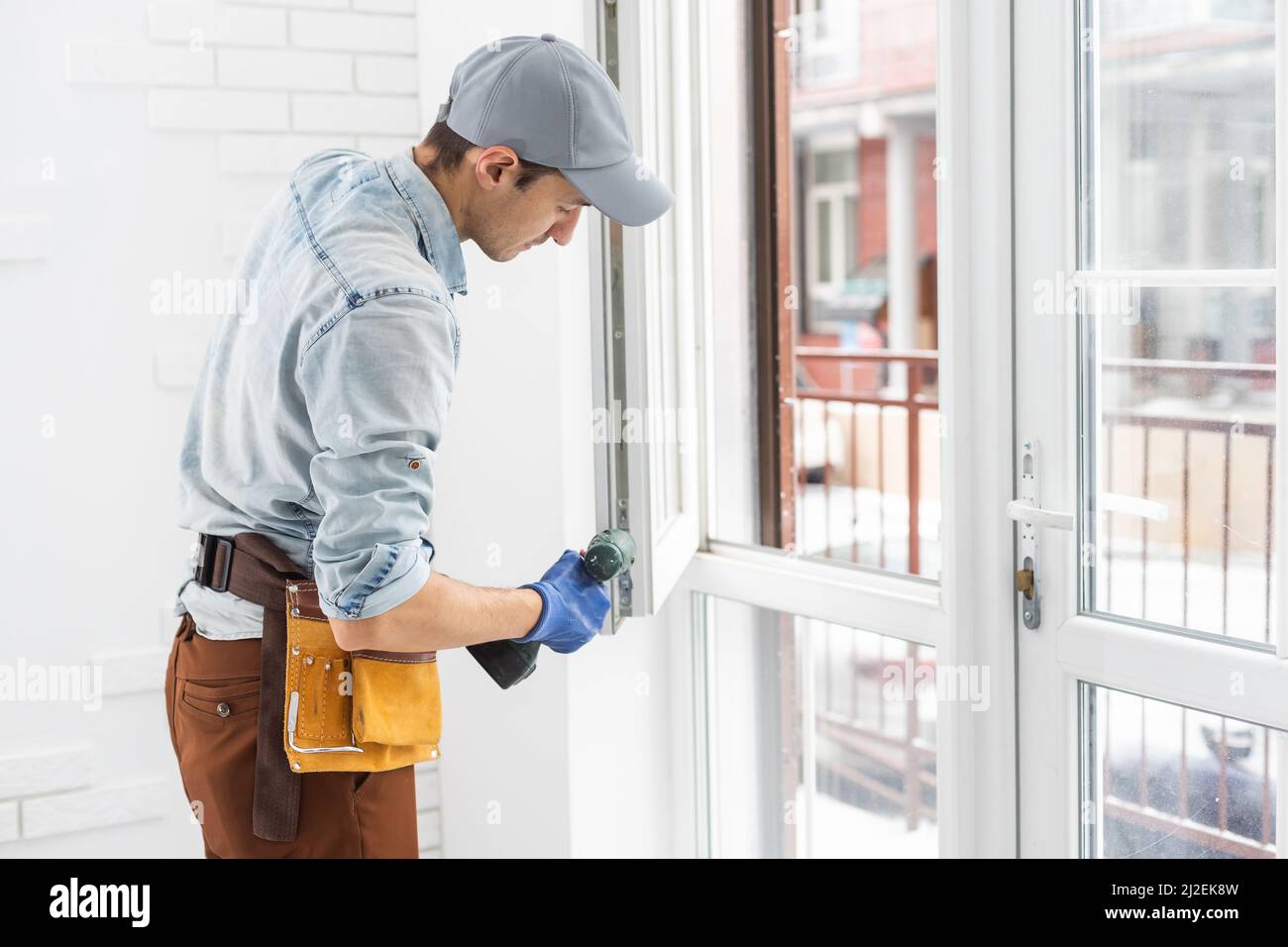Construction worker installing window in house. Handyman fixing the ...
