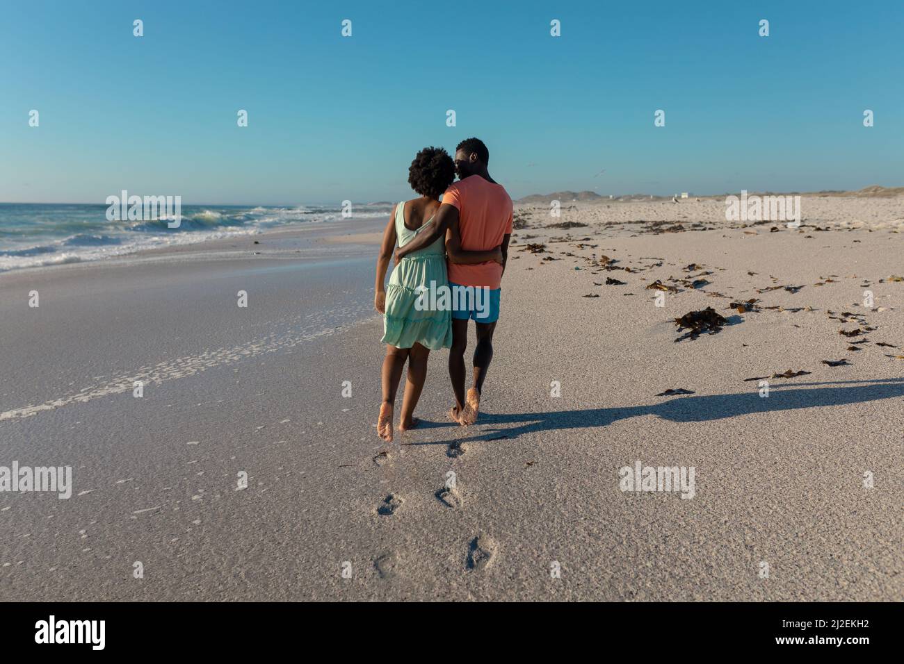 Full length rear view of african american couple walking with arms ...