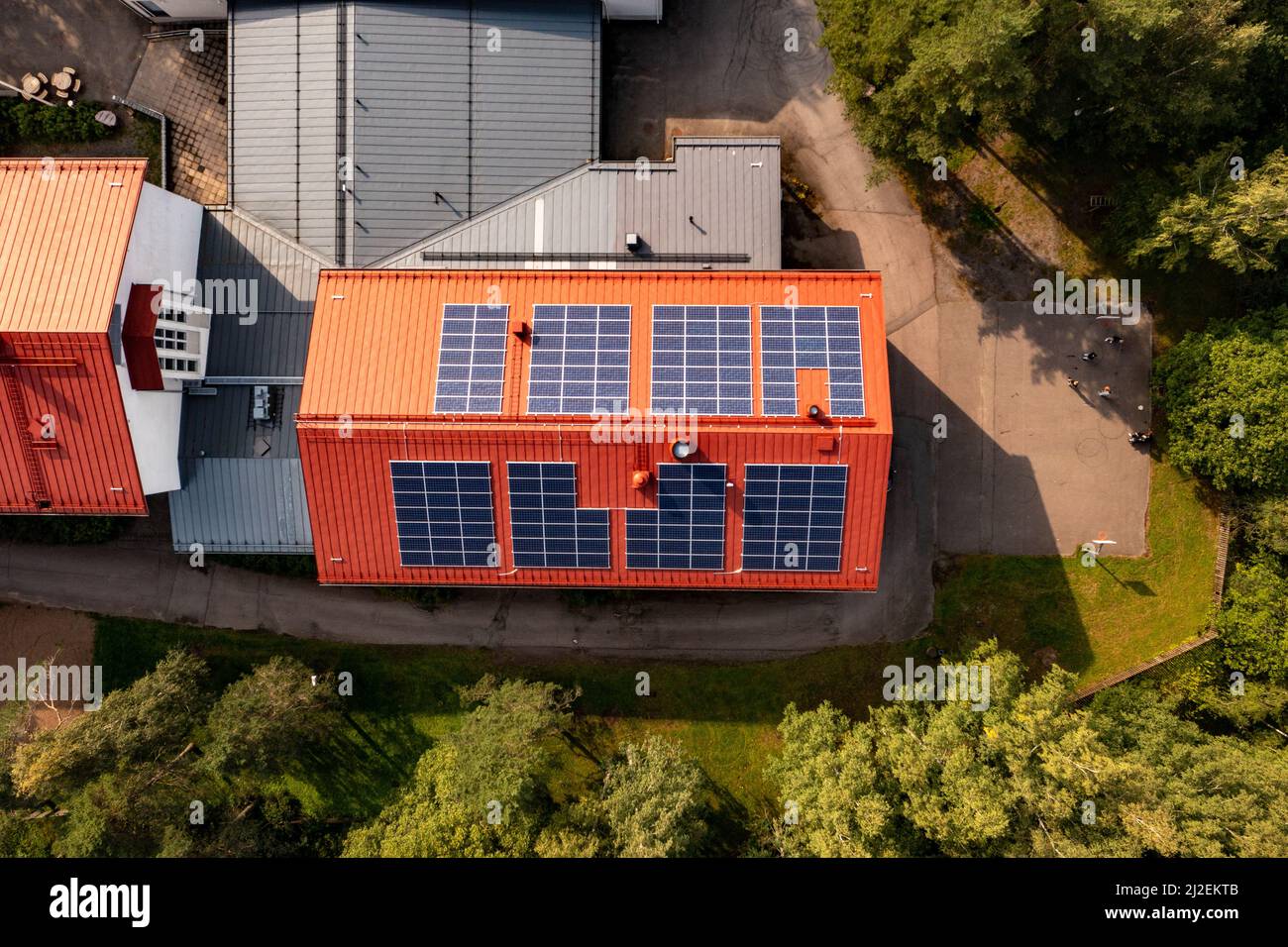 Aerial view above solar panels on a red building rooftop - top down ...