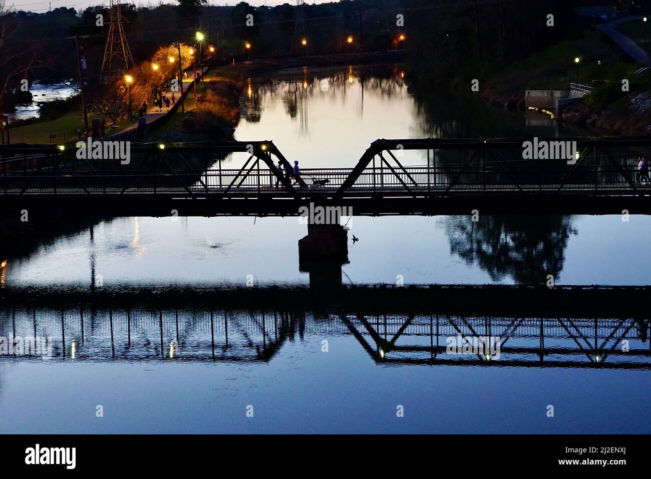 A bridge with the reflection over a river a dusk Stock Photo - Alamy