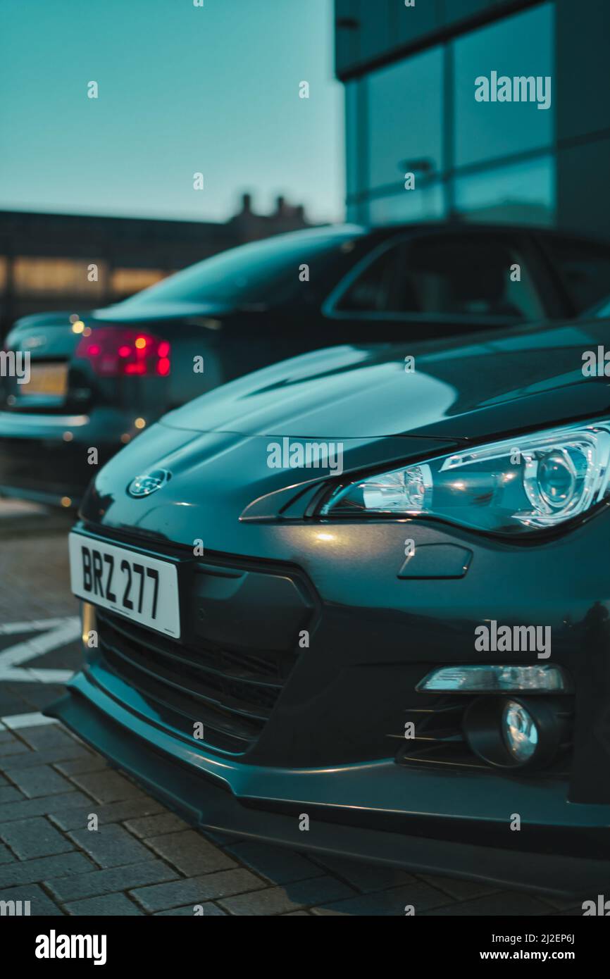 The vertical shot of a grey Subaru BRZ car parked on a park lot with a ...
