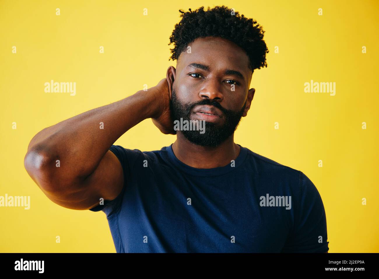Portrait of handsome Afro man with hand on hair against yellow ...