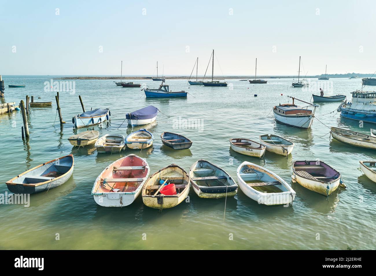A cluster of small boats anchored on the river thames estuary at Leigh ...