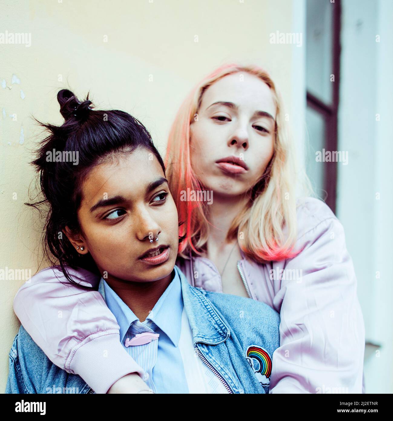 Two teenage girls infront of university building smiling, having fun ...