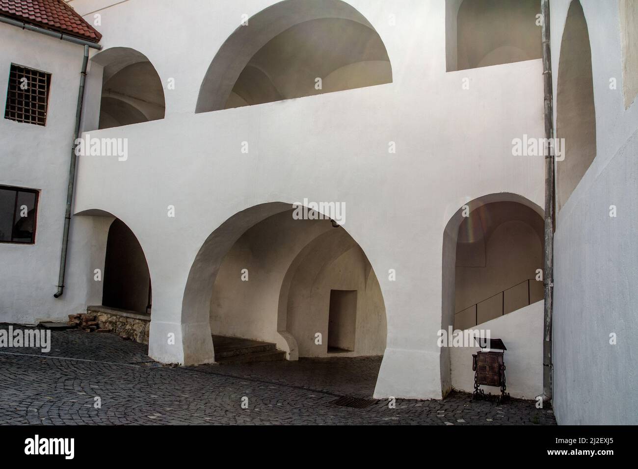 Image of the castle courtyard with white arches and stone pavement ...