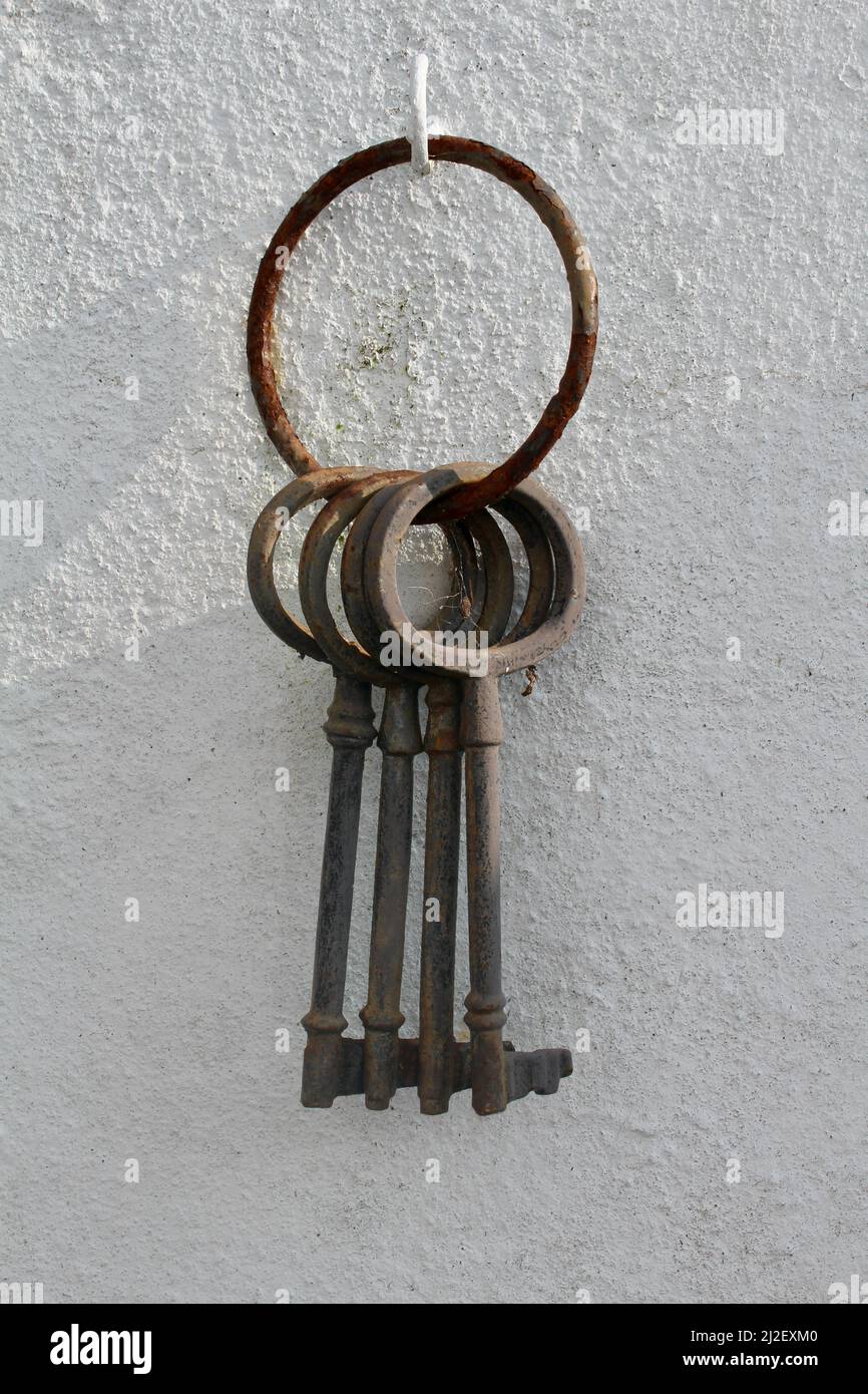 Old bunch of keys hanging on white wall Stock Photo - Alamy