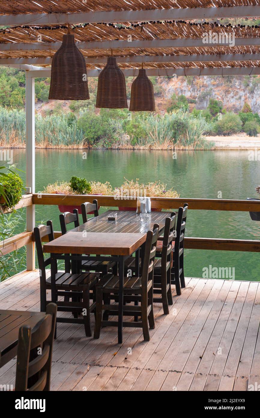 Wooden table on terrace in cafe by the river. Vertical photo Stock ...