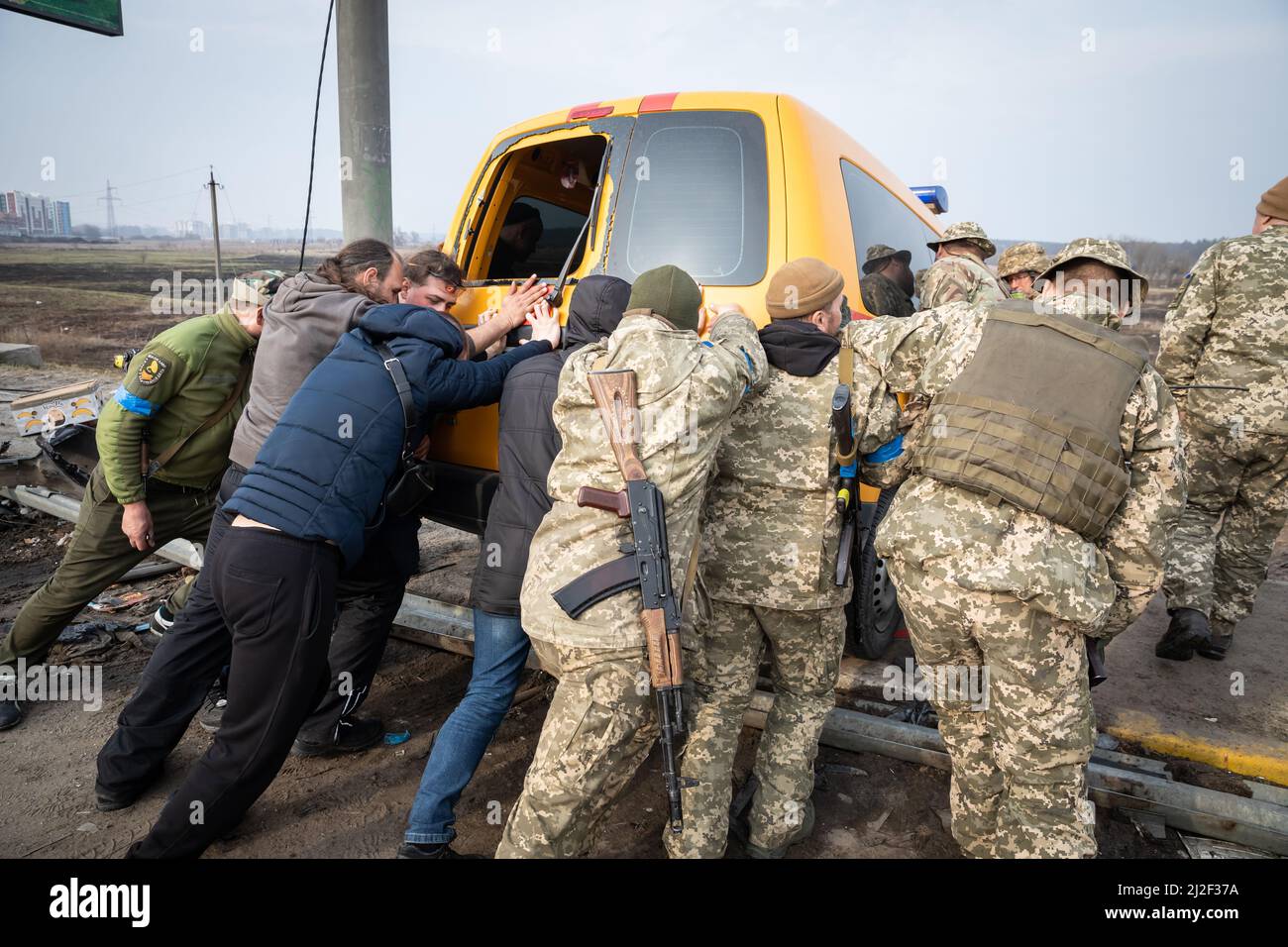 Soldiers and volunteers pushing sunken car , pictured 31.3.2022 (CTK ...