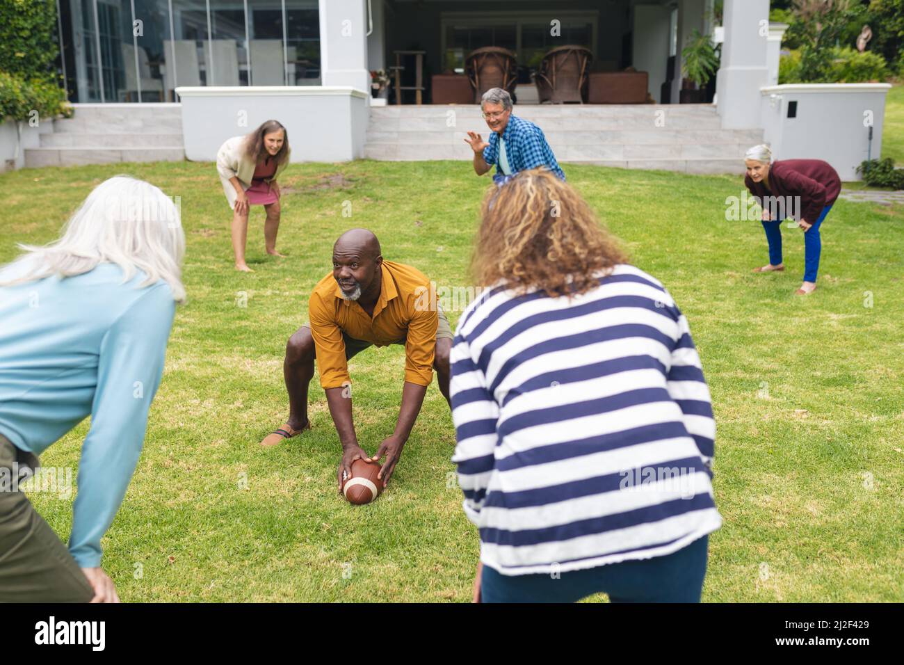 African american senior man playing rugby with caucasian friends in ...