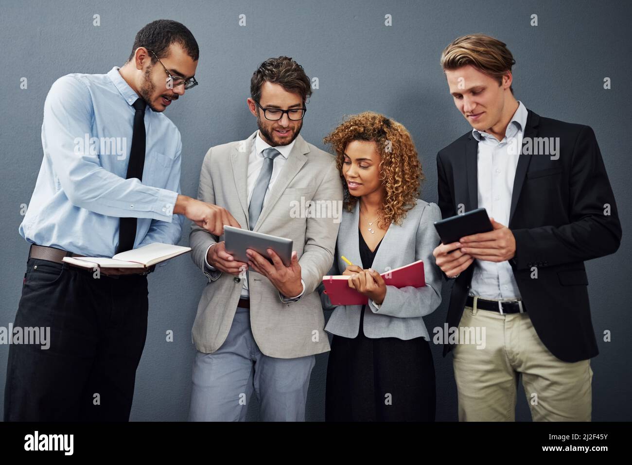 Whats that. Cropped shot of a group of businesspeople using digital ...