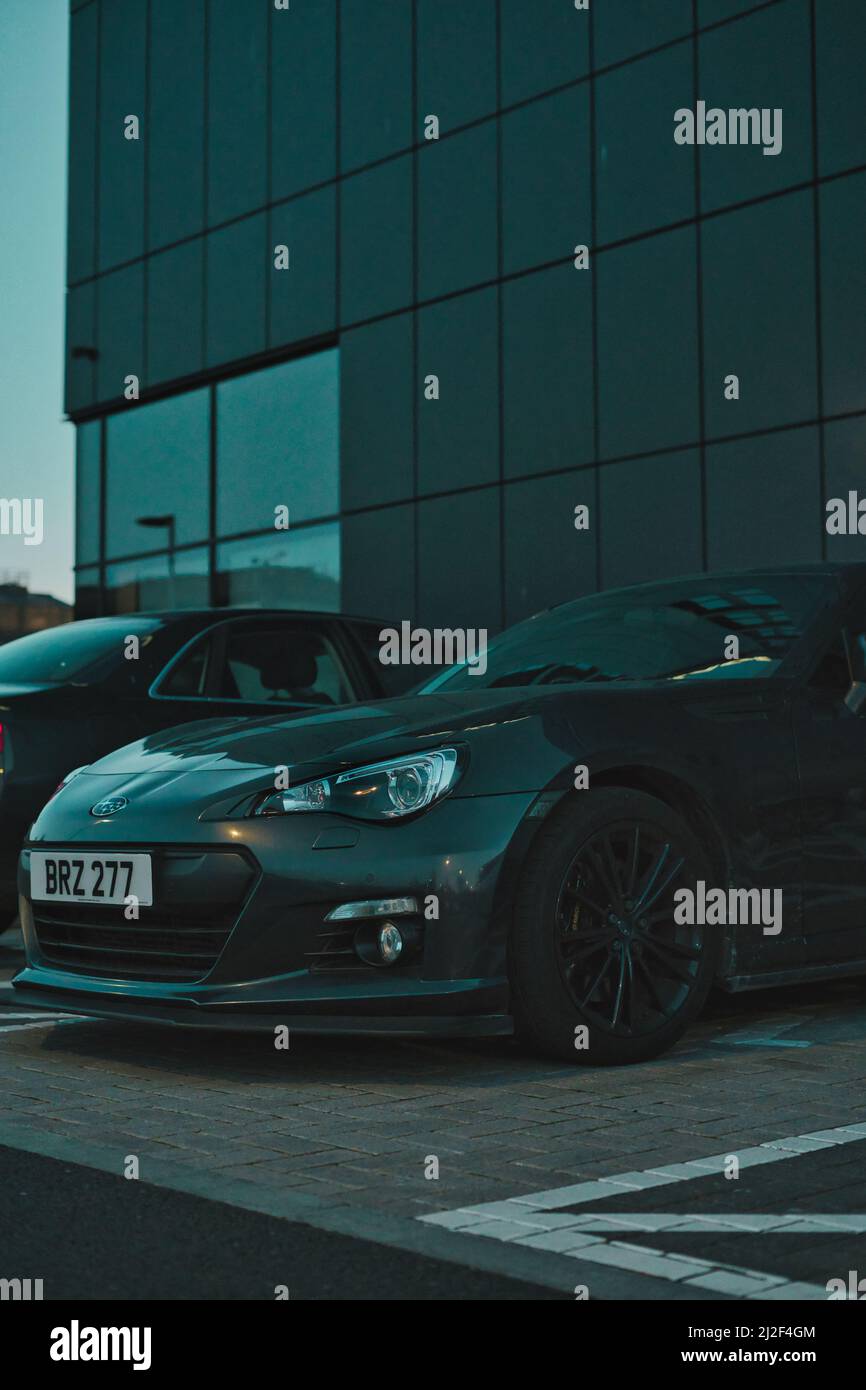 The vertical shot of a grey Subaru BRZ car parked in a parking lot with ...