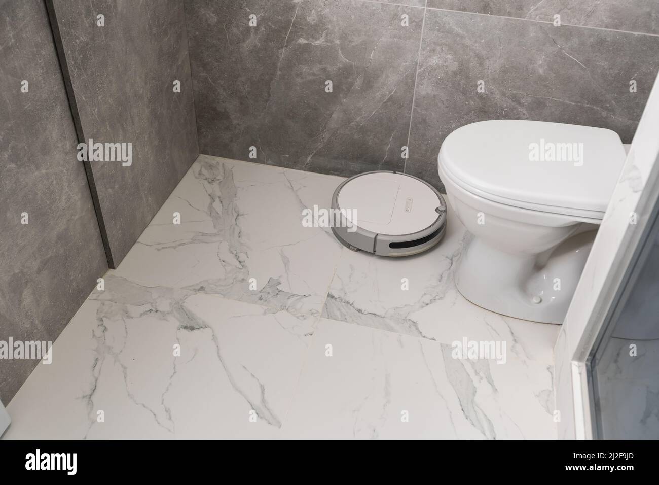 White robot vacuum cleaner in bathroom Stock Photo - Alamy