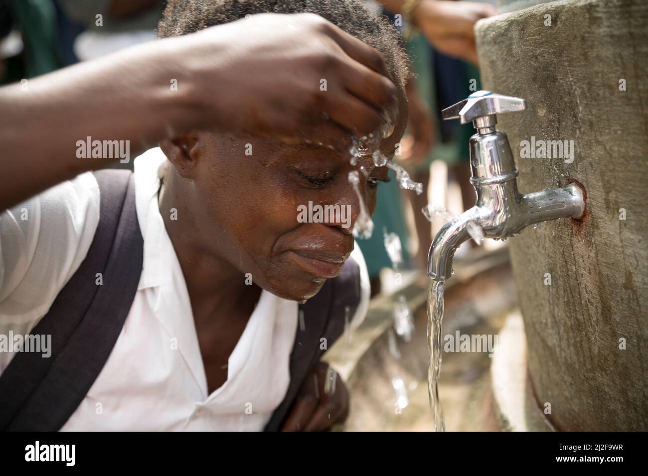 School students access clean drinking and washing water from a fountain ...