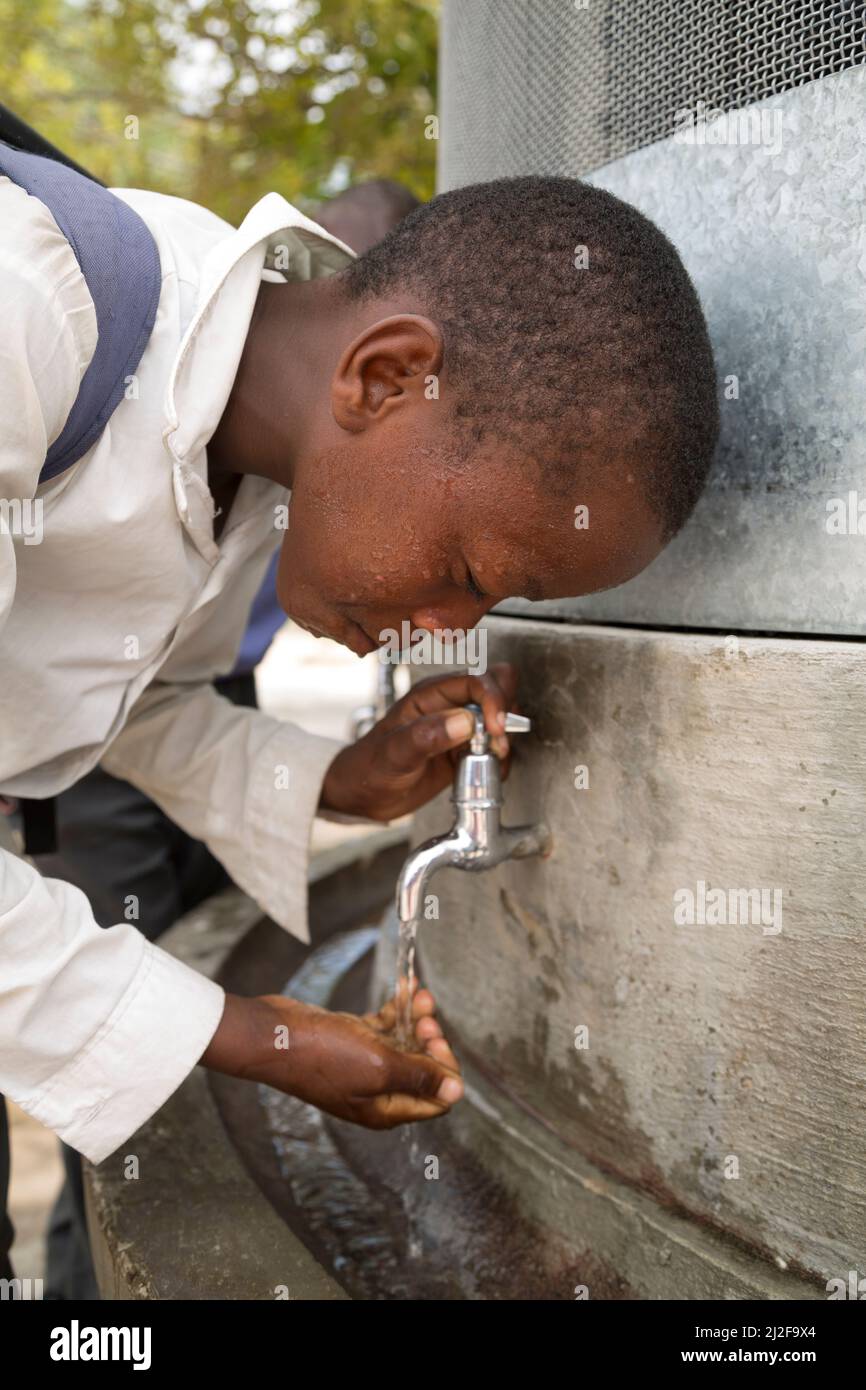 School students access clean drinking and washing water from a fountain ...