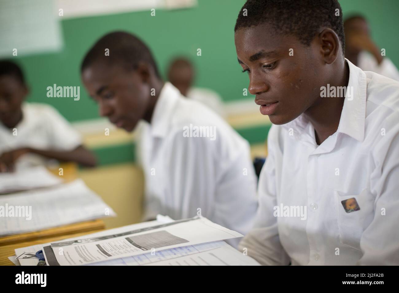 Secondary school students learning at desks in classroom in Oshana ...