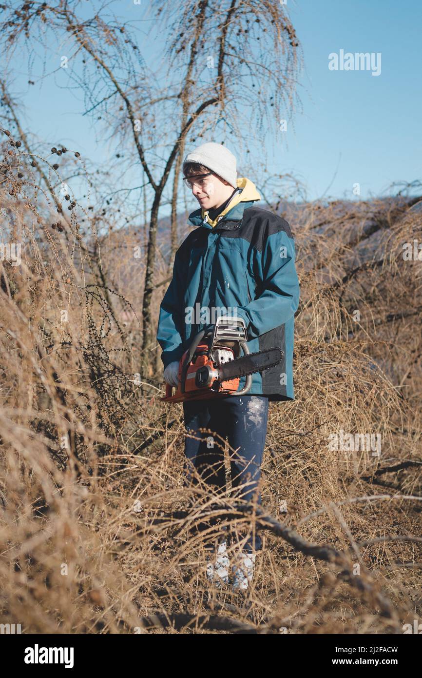 young 17-year-old temporary worker in work clothes wrestles with a ...
