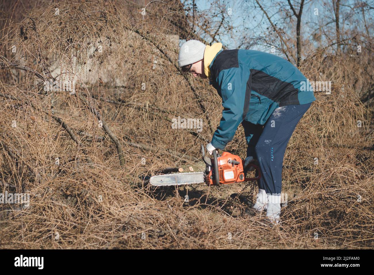 young 17-year-old temporary worker in work clothes wrestles with a ...