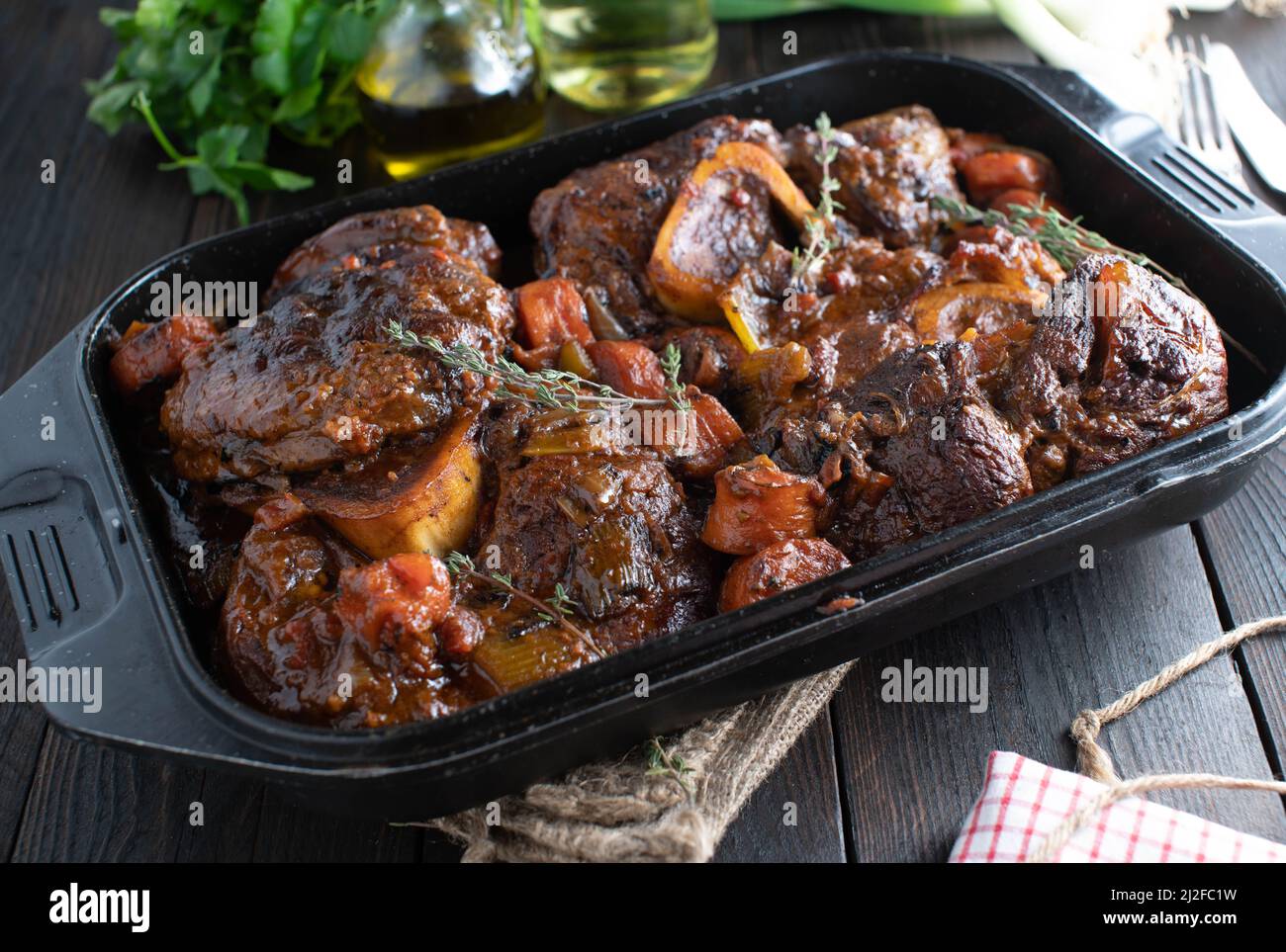 Braised veal shanks - Ossobuco. Served in a roasting pan on rustic and ...