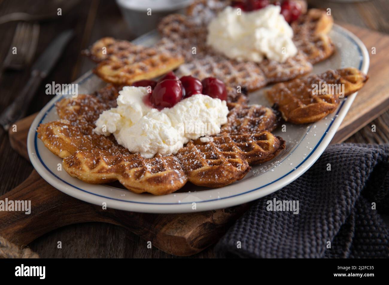 Fresh waffles with whipped cream and cherries. Traditional german ...