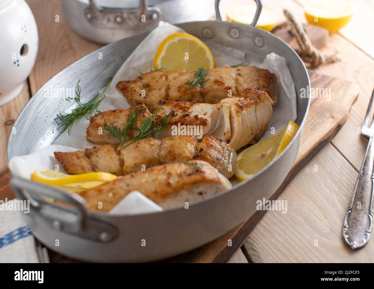 Pan-fried pollock or coalfish with lemon and dill in a roasting pan ...