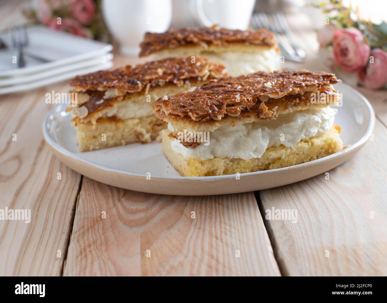 Sliced cakes on a plate. Delicious sheet cake filled with whipped cream ...