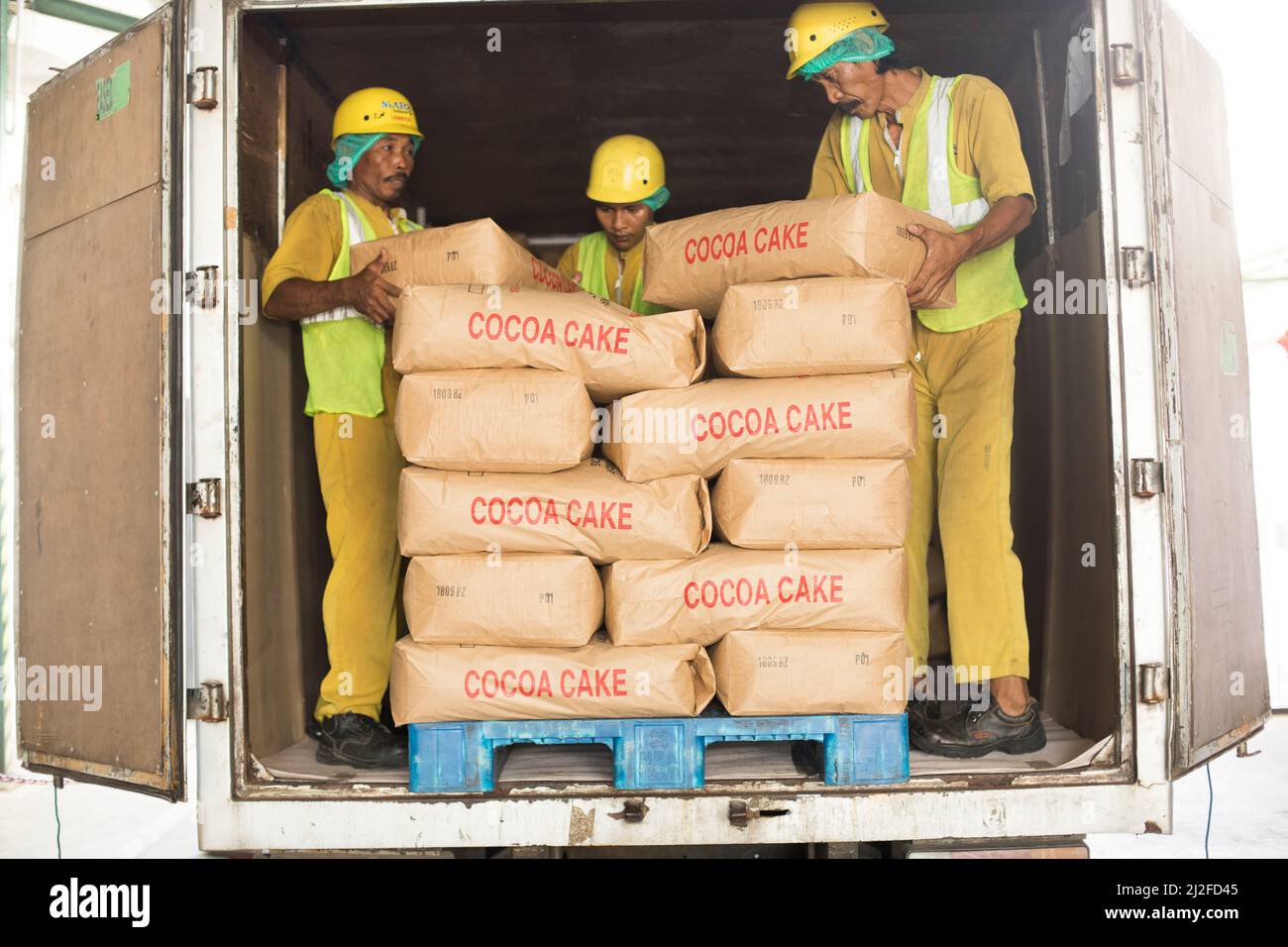 Workers unloading cocoa cake Mars Chocolate Indonesia warehouse in West ...