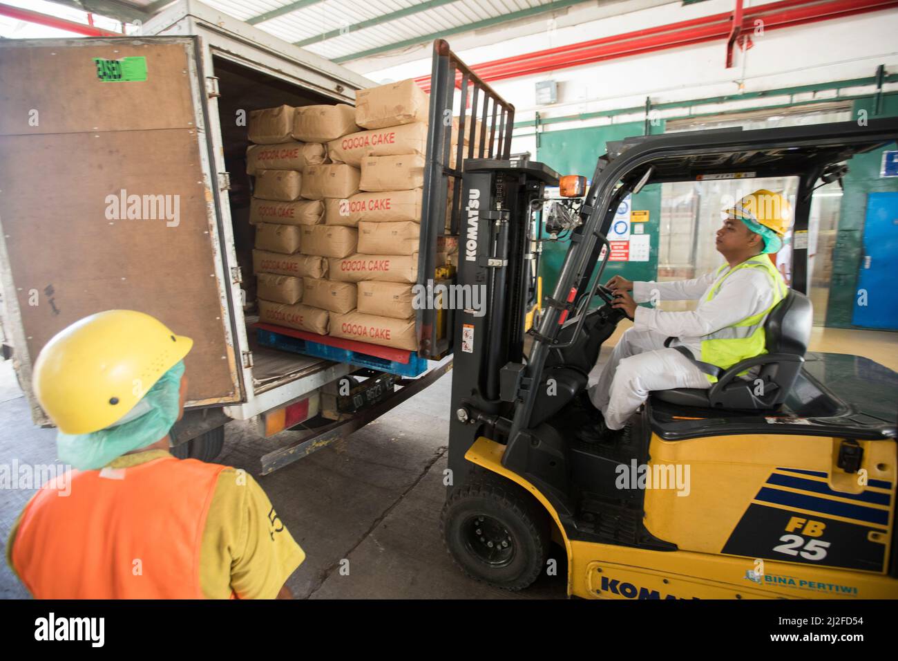 Workers unloading cocoa cake Mars Chocolate Indonesia warehouse in West ...