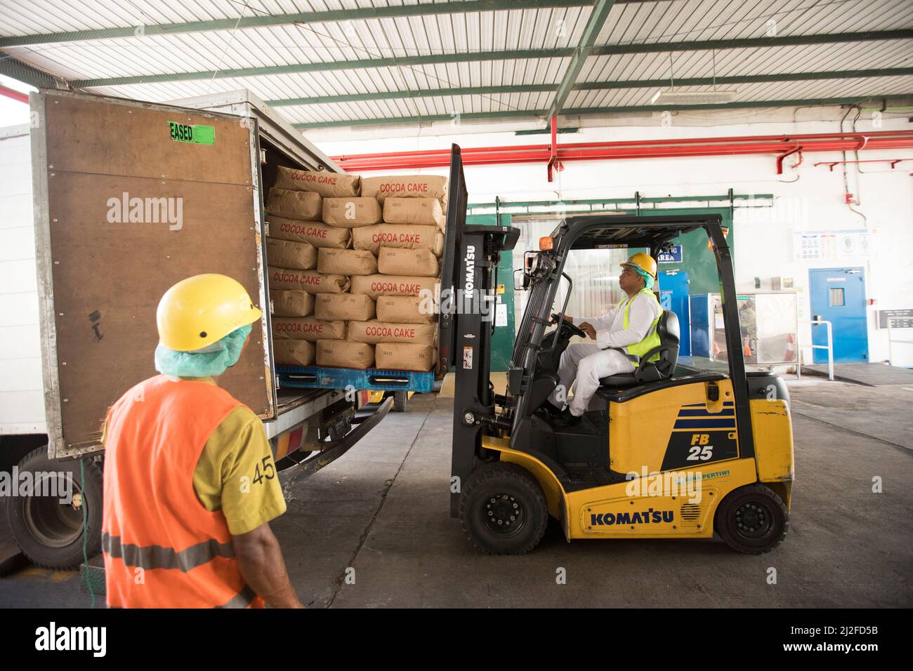 Workers unloading cocoa cake Mars Chocolate Indonesia warehouse in West ...