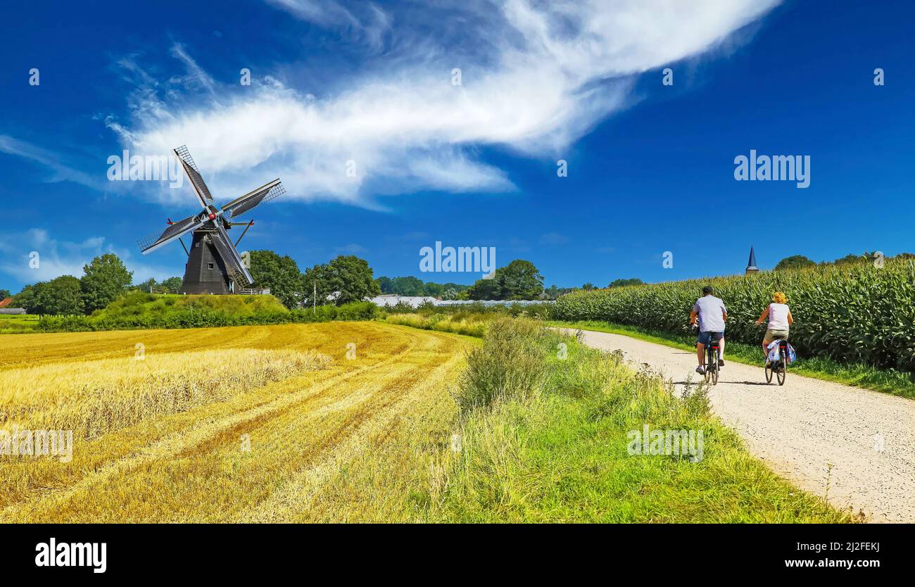 View on cycling path with cyclists couple in rural dutch limburg maas ...