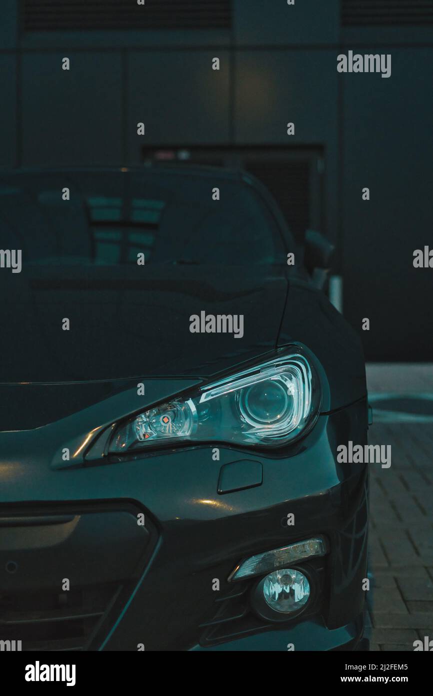 The vertical shot of a grey Subaru BRZ car parked in a parking lot with ...