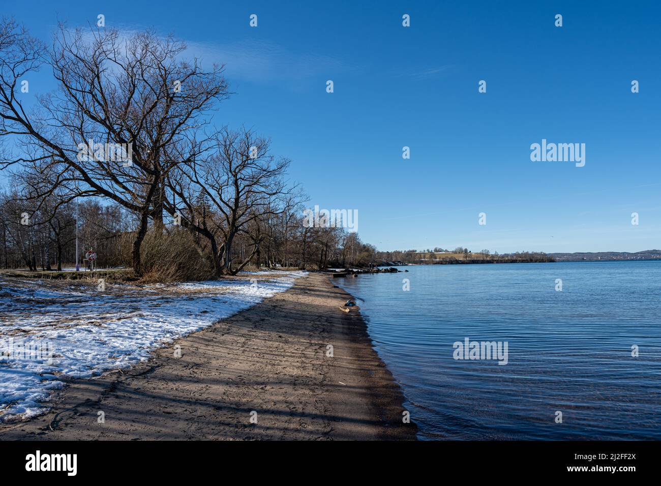 A winter beach covered with snow and a blue sky in the background Stock ...