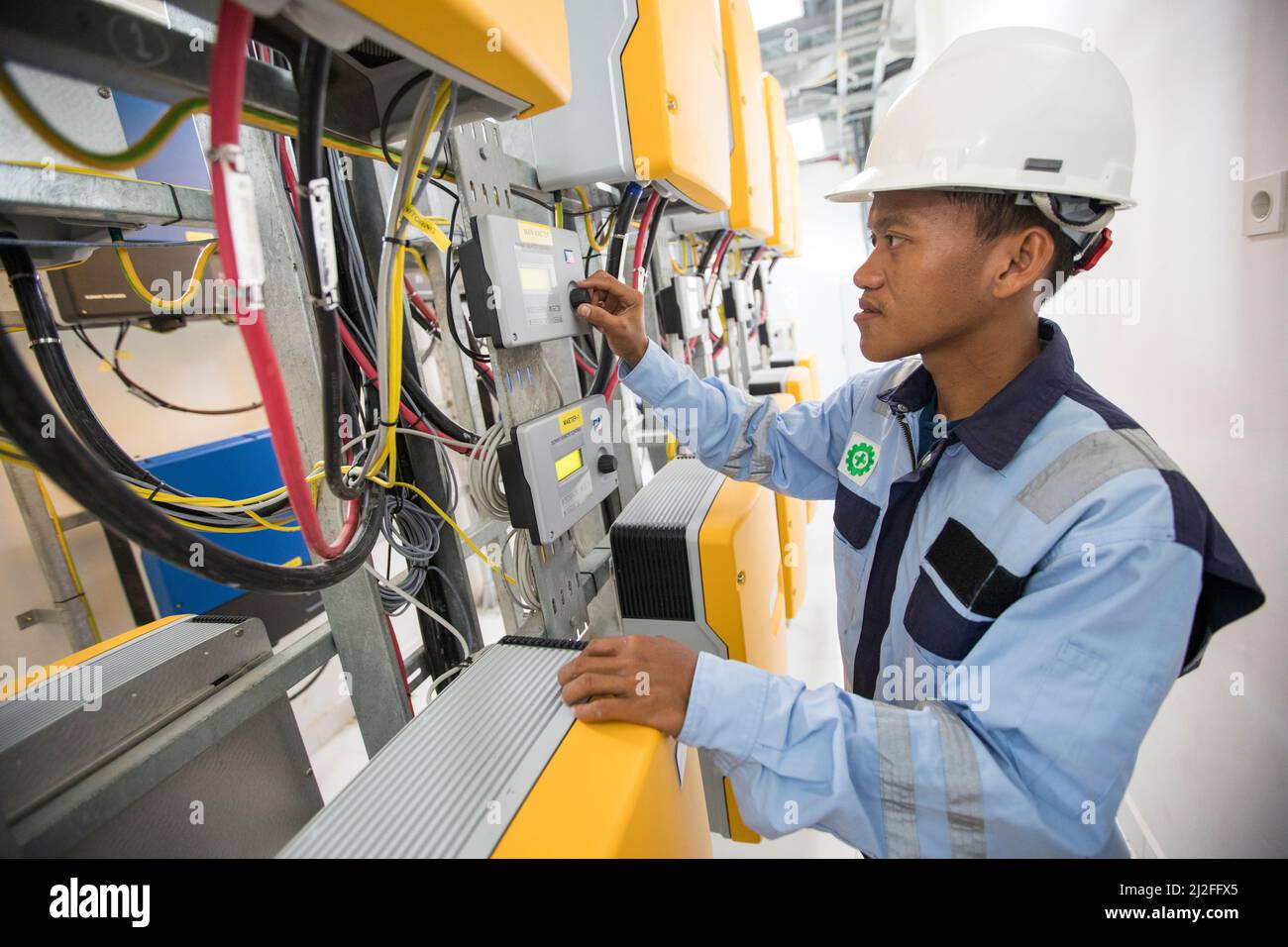 An electrical technician operates equipment at a solar electricity ...