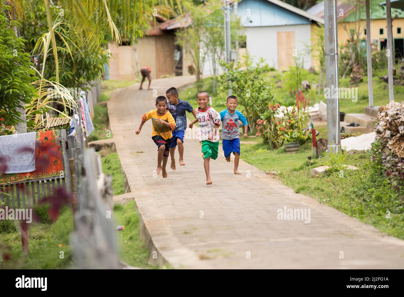 Children race down a village road on Karampuang Island, Indonesia, Asia ...