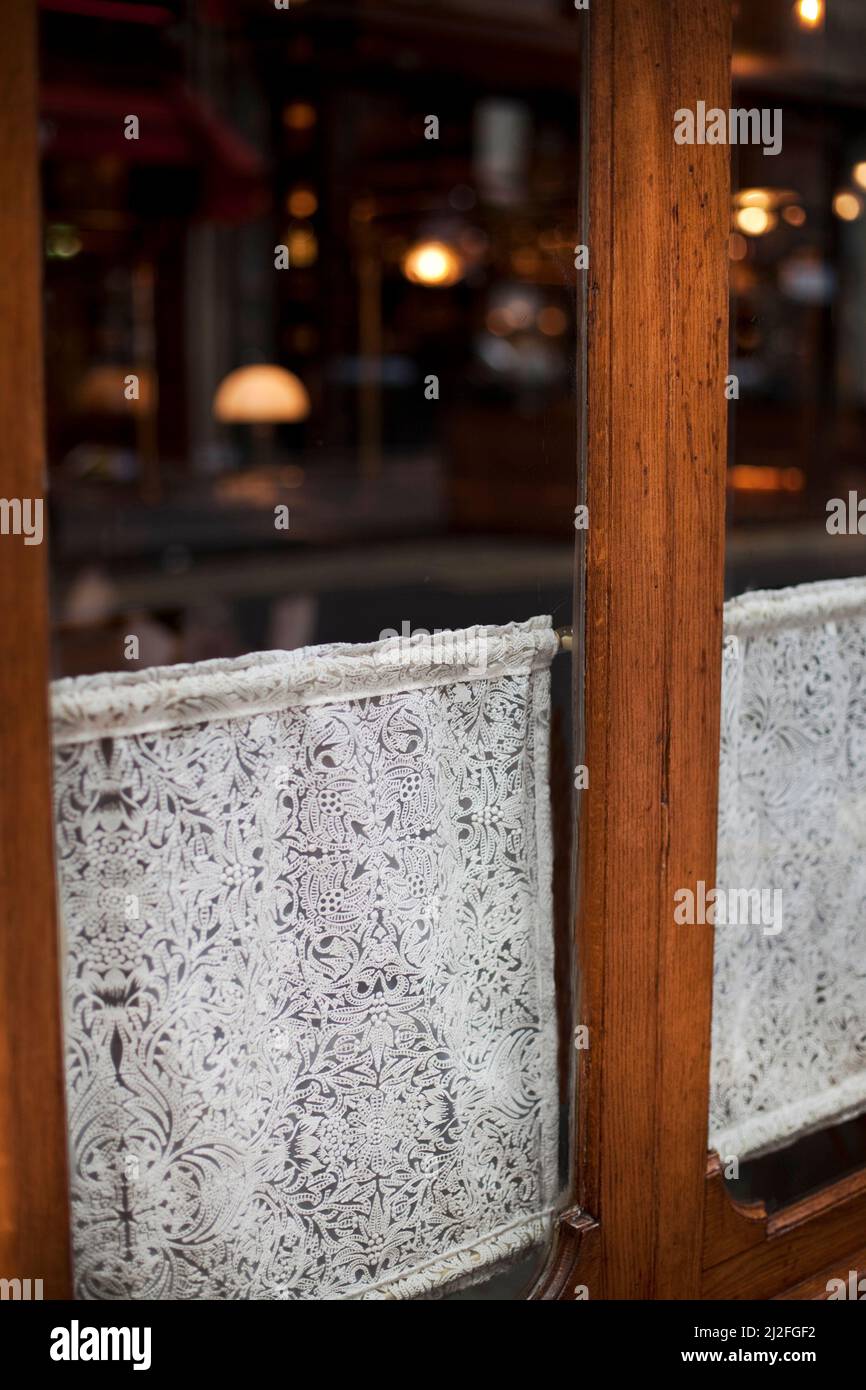 Old lace curtain and vintage wooden window of a cafe in France Stock ...