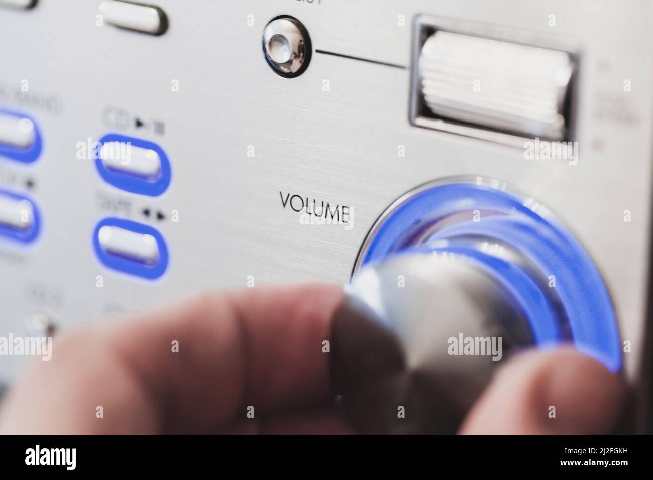 Male hand is on a volume control knob, close up-photo with selective ...