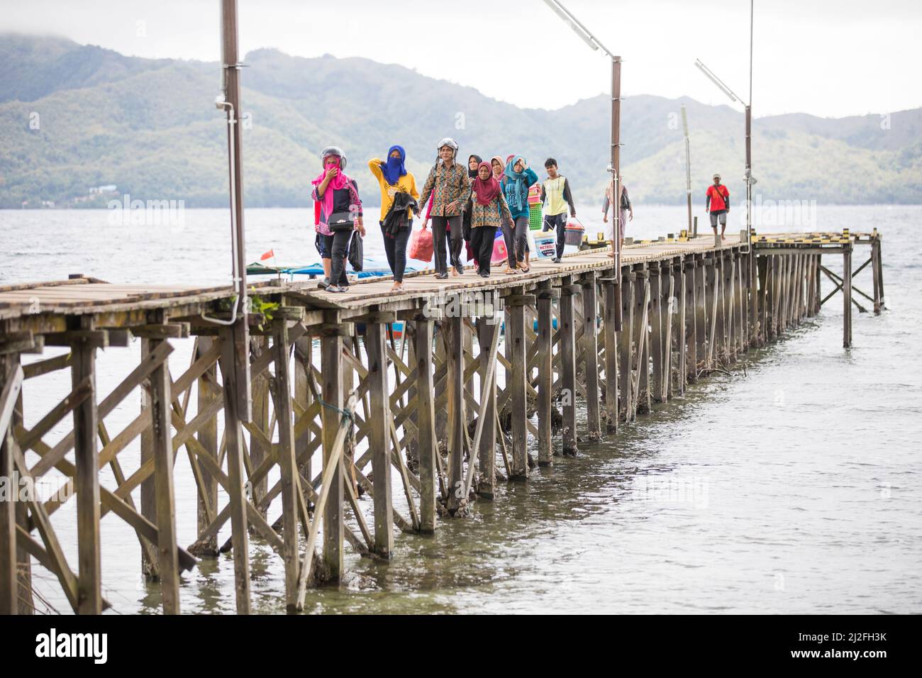Passengers on the island of Karampuang await the arrival of a ferryboat ...