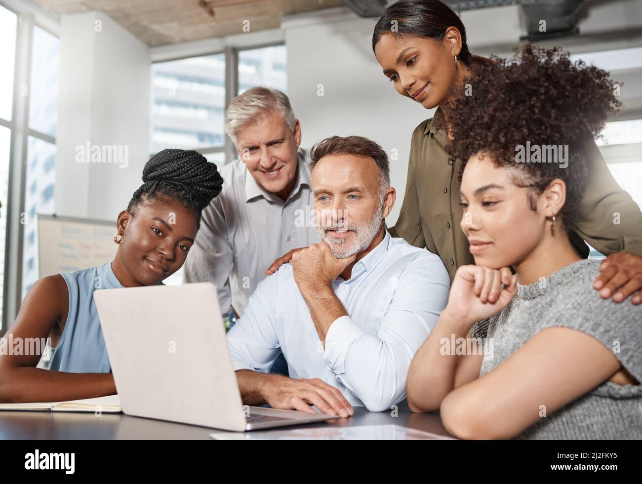 This is interesting. Shot of a group of businesspeople using a laptop ...