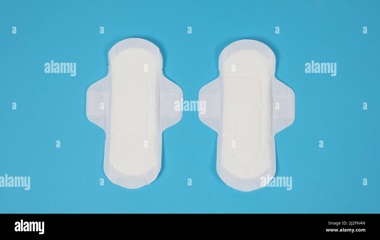 Woman sanitary napkins on blue background. Top view. Absorbent pads ...